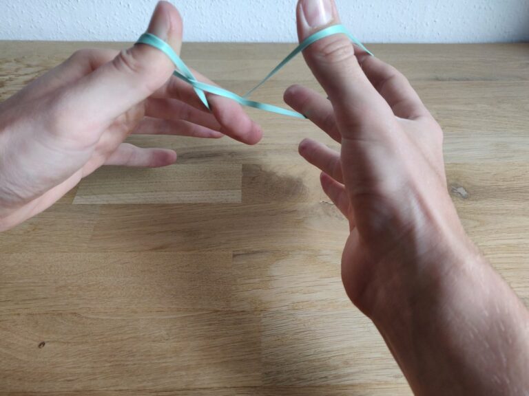 Rubber band through finger trick: Tutorial with images